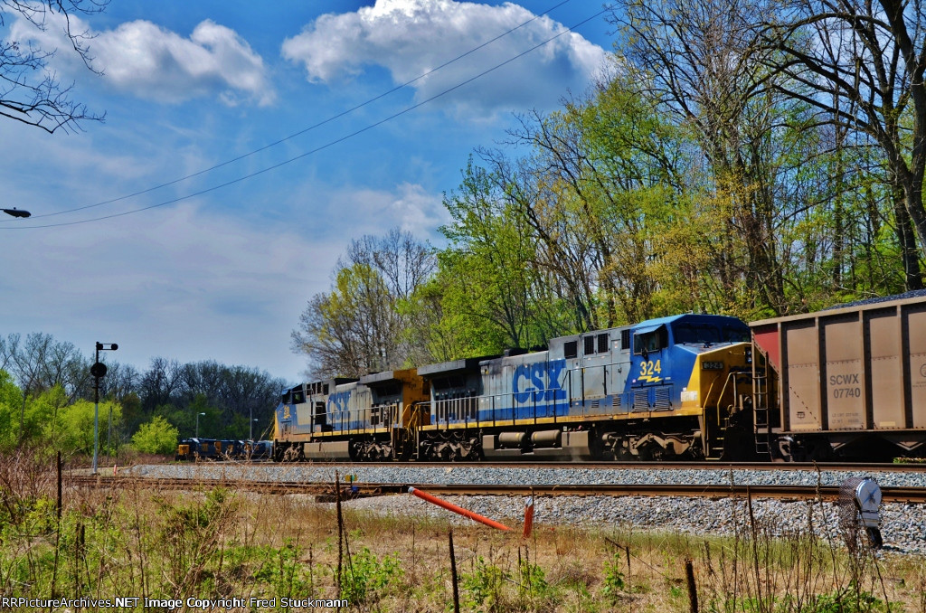 CSX 324 and it's leader pass the local working in the Hill Yard.